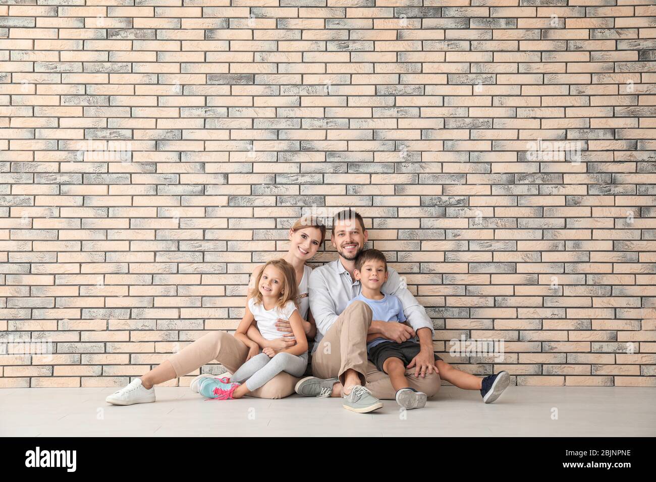 Happy family sitting on floor in new empty flat Stock Photo - Alamy