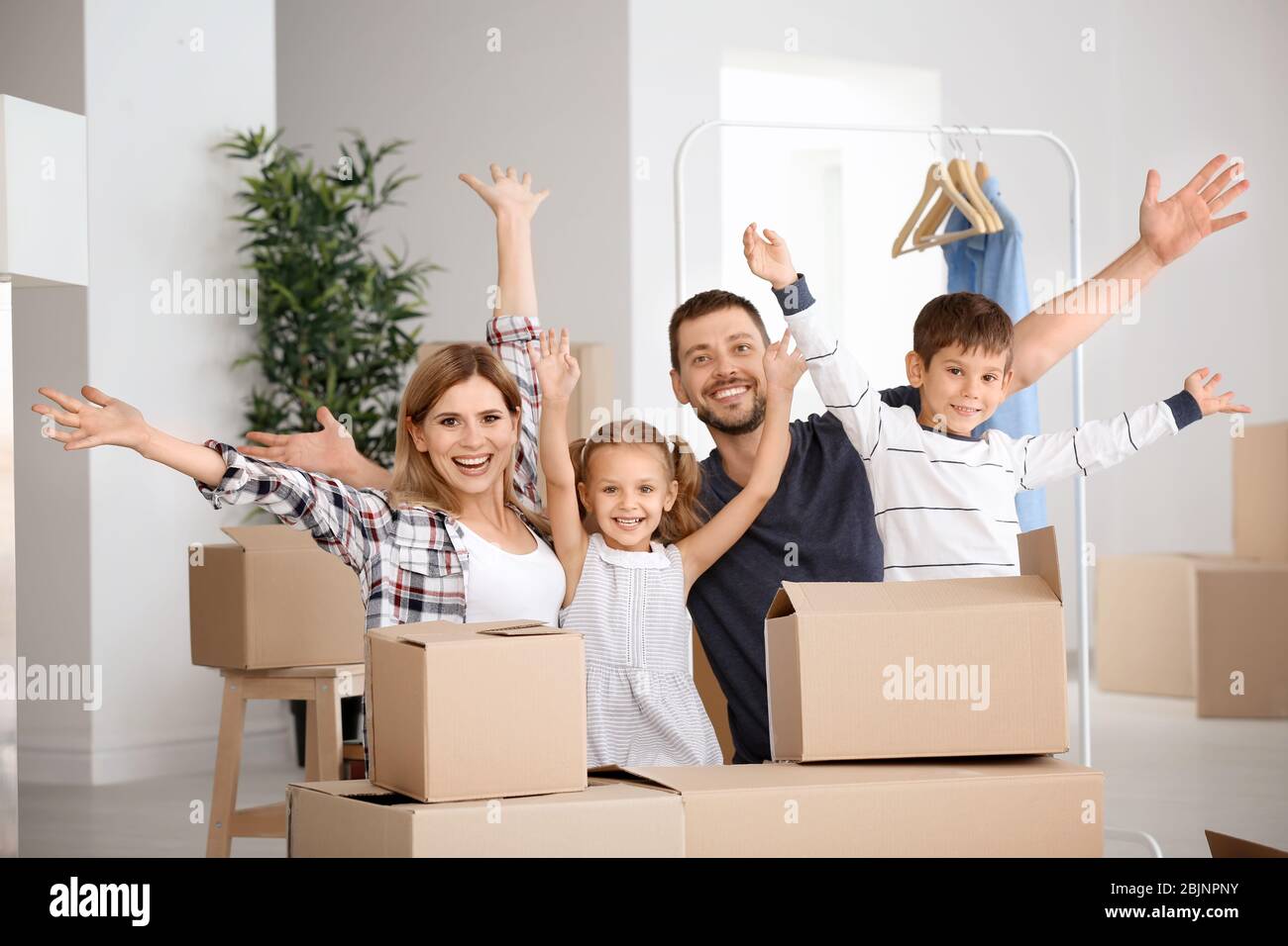 Happy family with cardboard boxes in new flat Stock Photo - Alamy
