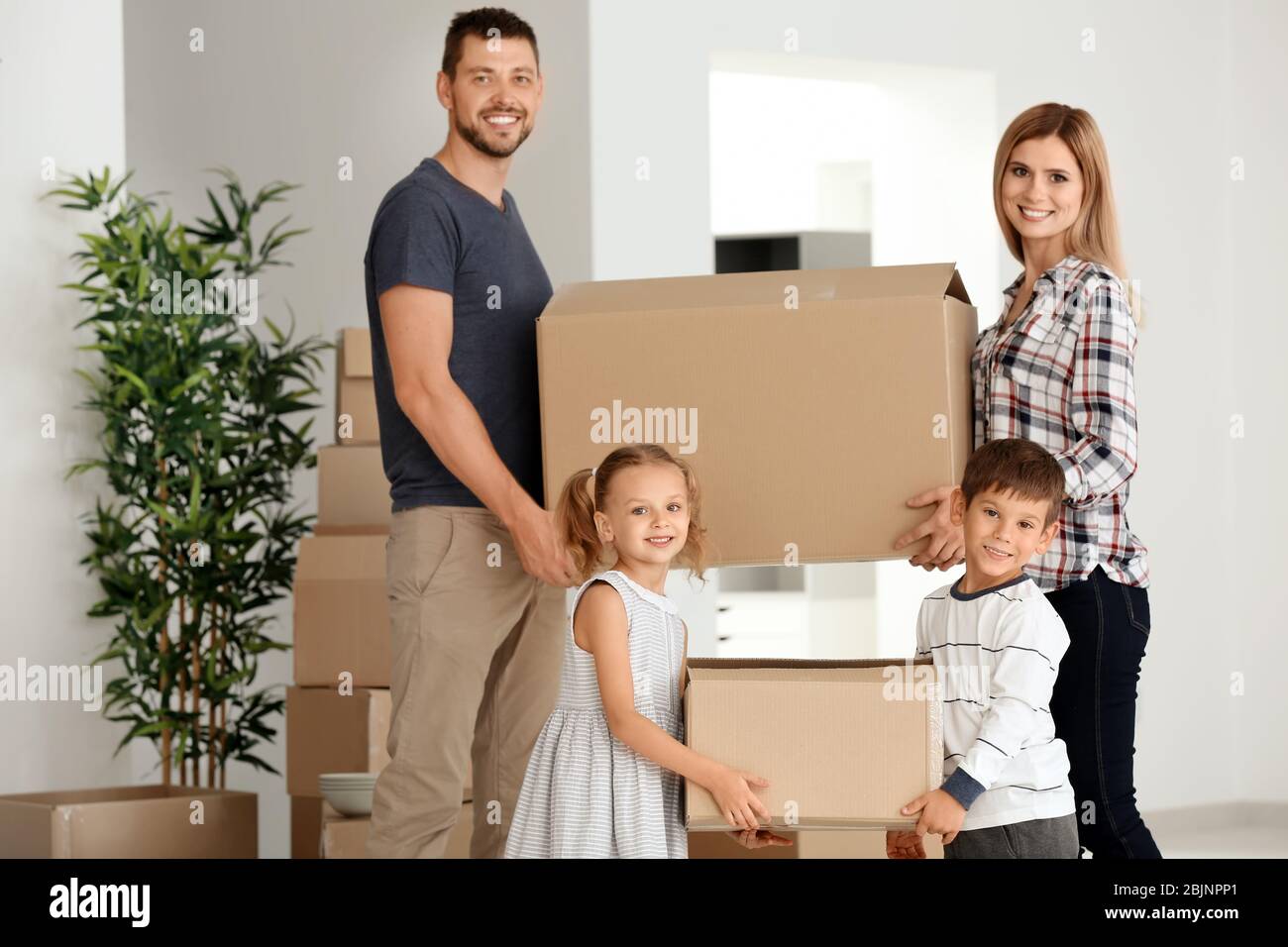 Happy family unpacking things in new flat Stock Photo - Alamy