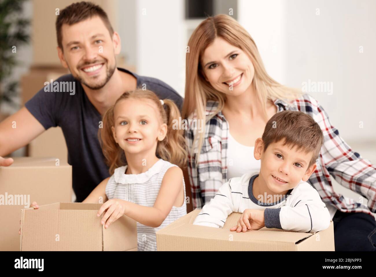 Happy family unpacking things in new flat Stock Photo - Alamy