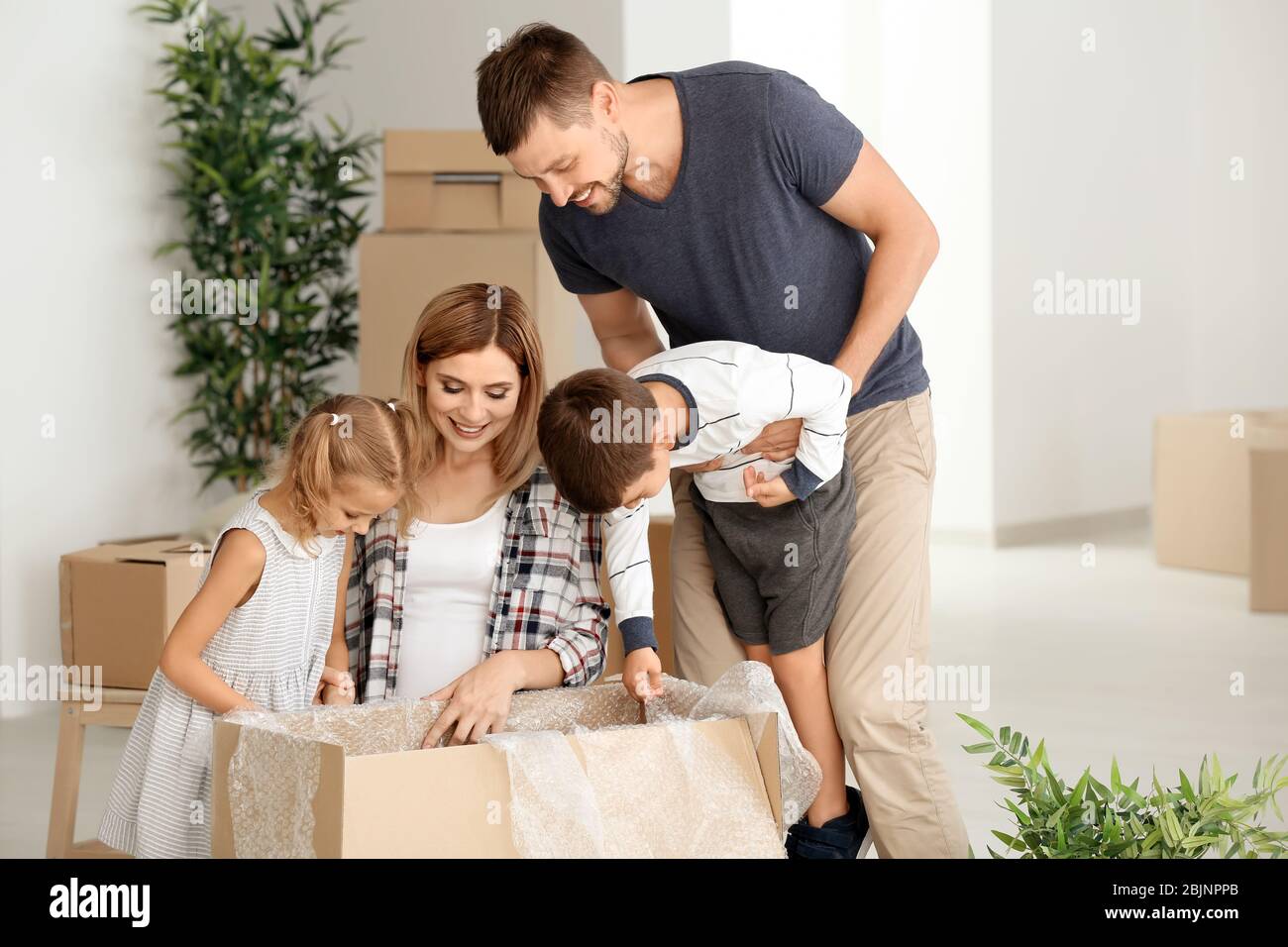 Happy family unpacking things in new flat Stock Photo - Alamy