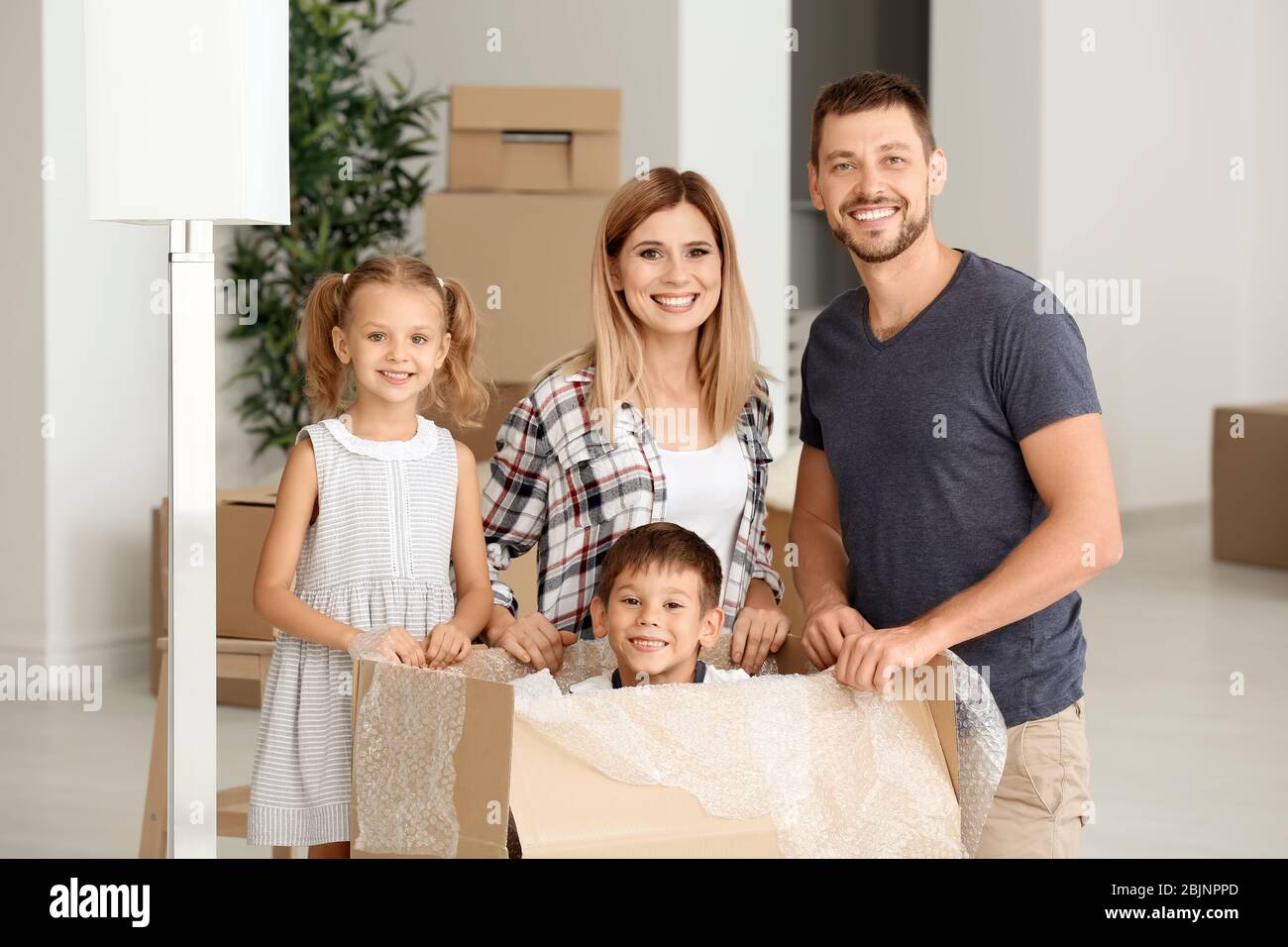 Happy family unpacking things in new flat Stock Photo - Alamy