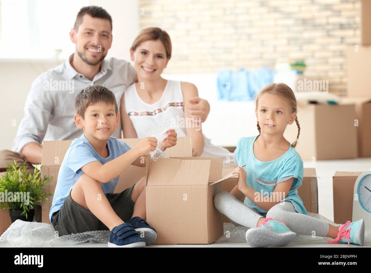Happy family unpacking things in new flat Stock Photo - Alamy