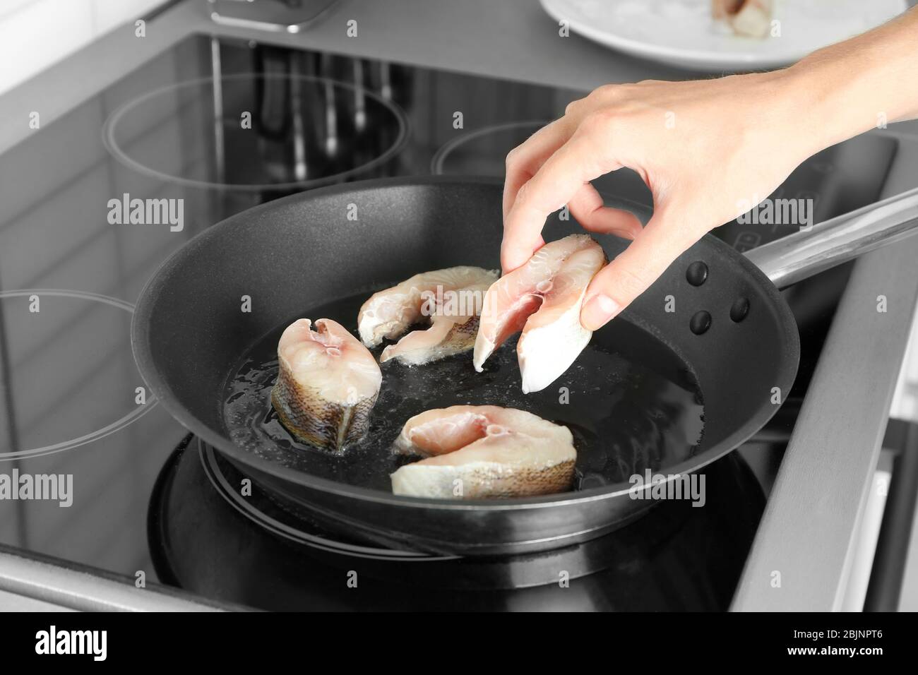 Woman frying fish steaks on pan in kitchen Stock Photo - Alamy