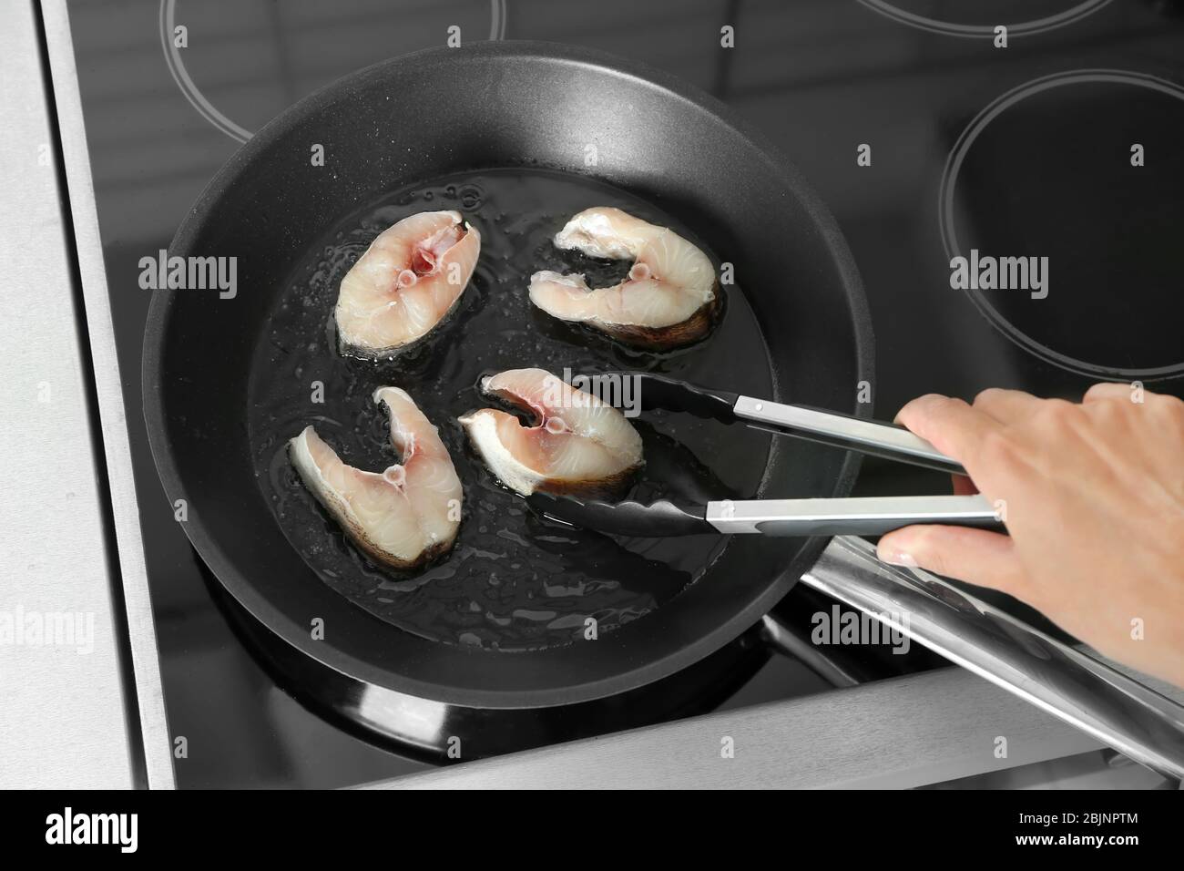 Woman frying fish hi-res stock photography and images - Alamy