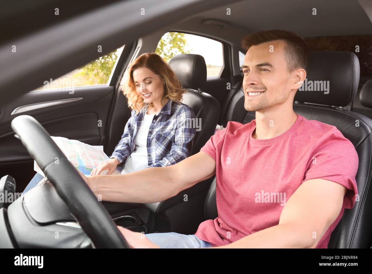 Beautiful young couple in car Stock Photo - Alamy
