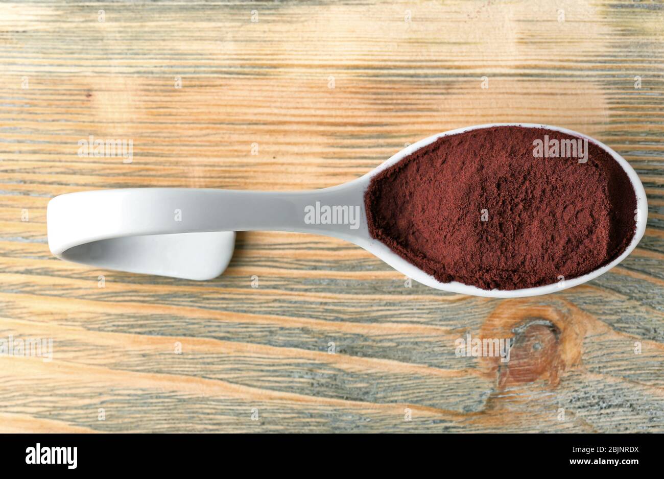 Spoon with acai powder on wooden background Stock Photo - Alamy