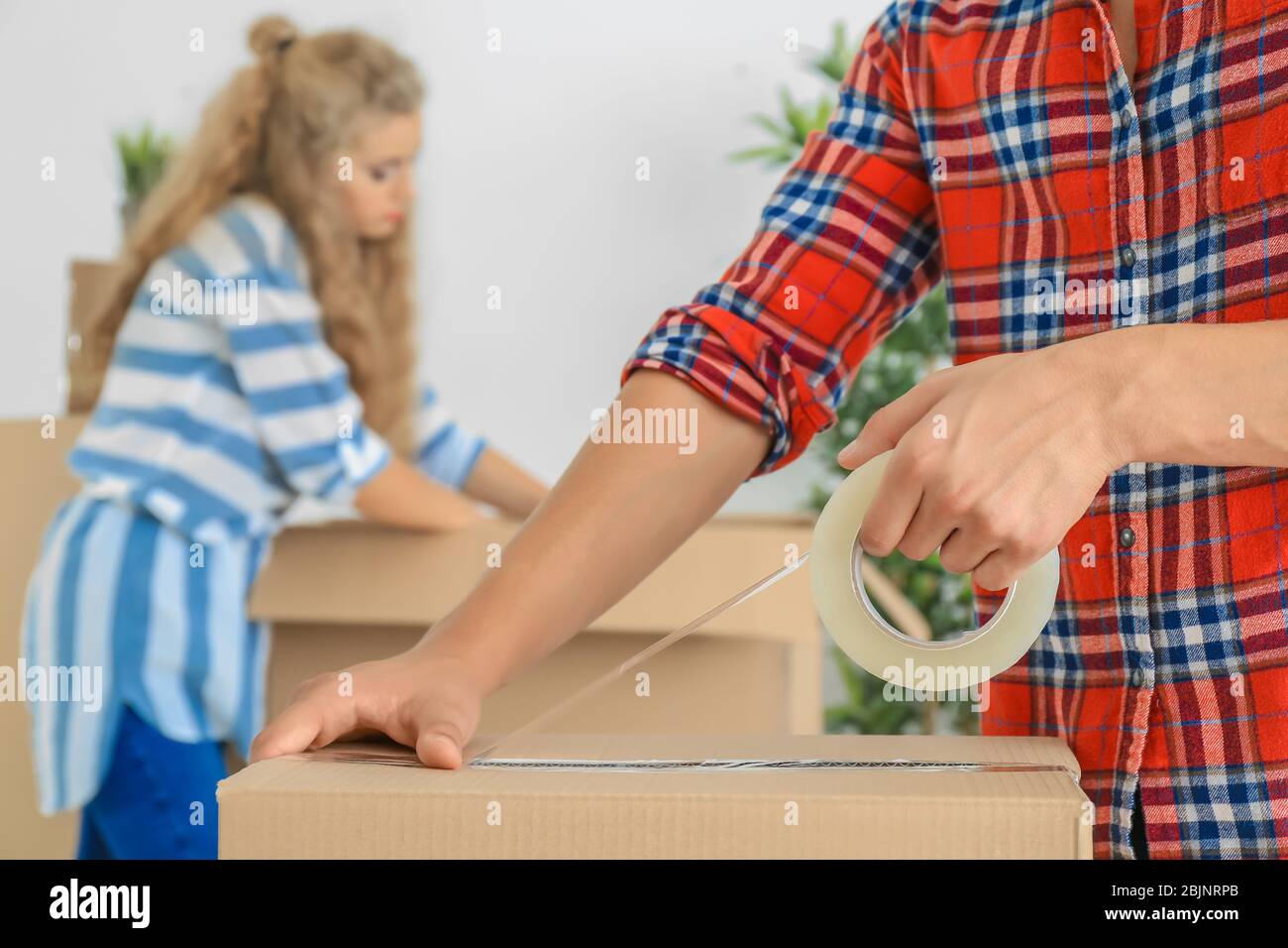 Young man packing box, indoors Stock Photo - Alamy
