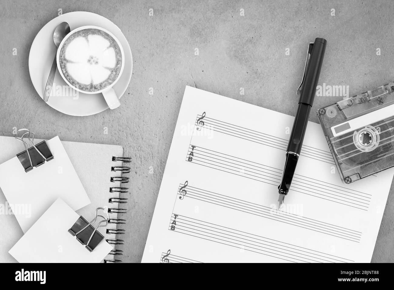 Sheet music, fountain pen, tape cassette and coffee latte on wooden ...