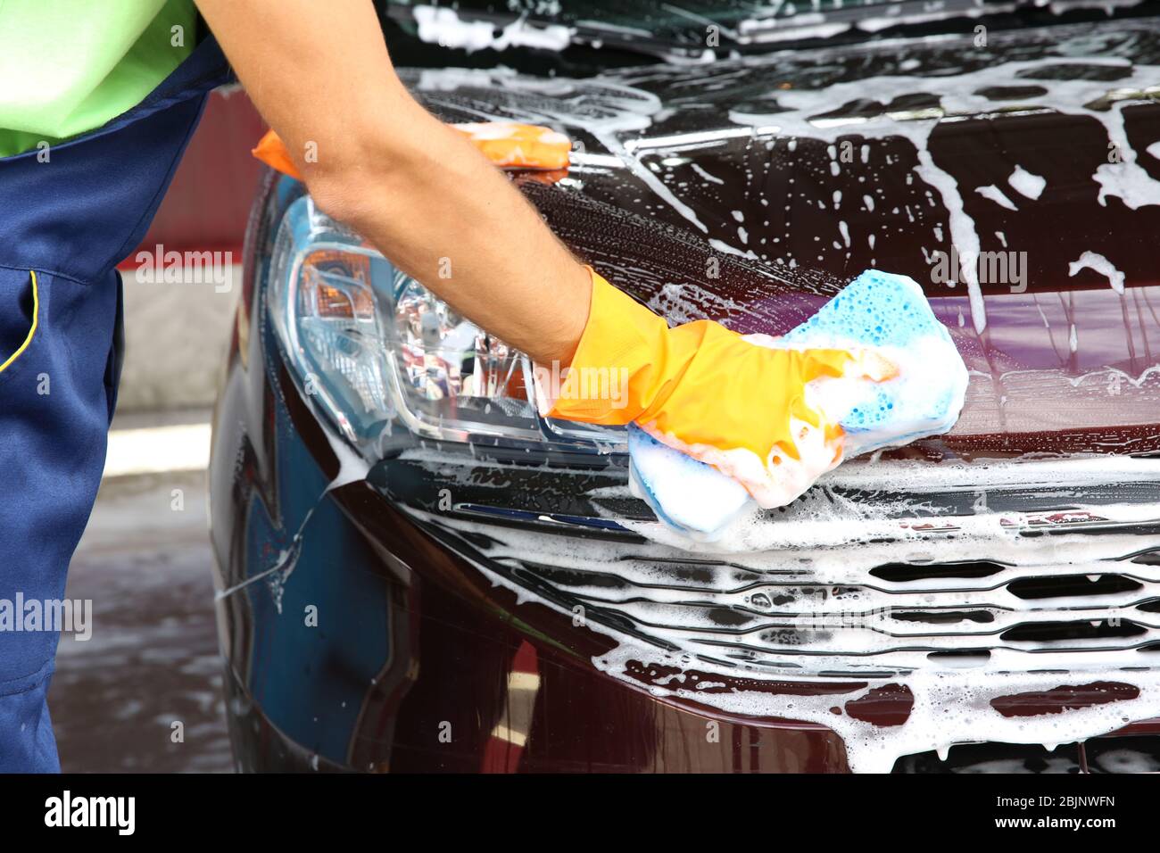 Man washing automobile hood with sponge Stock Photo - Alamy