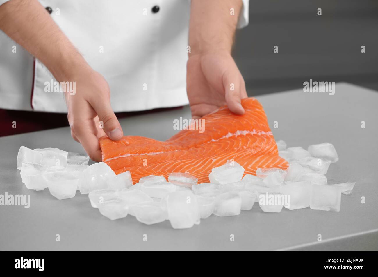 Chef putting fresh salmon fillet on table in kitchen Stock Photo - Alamy