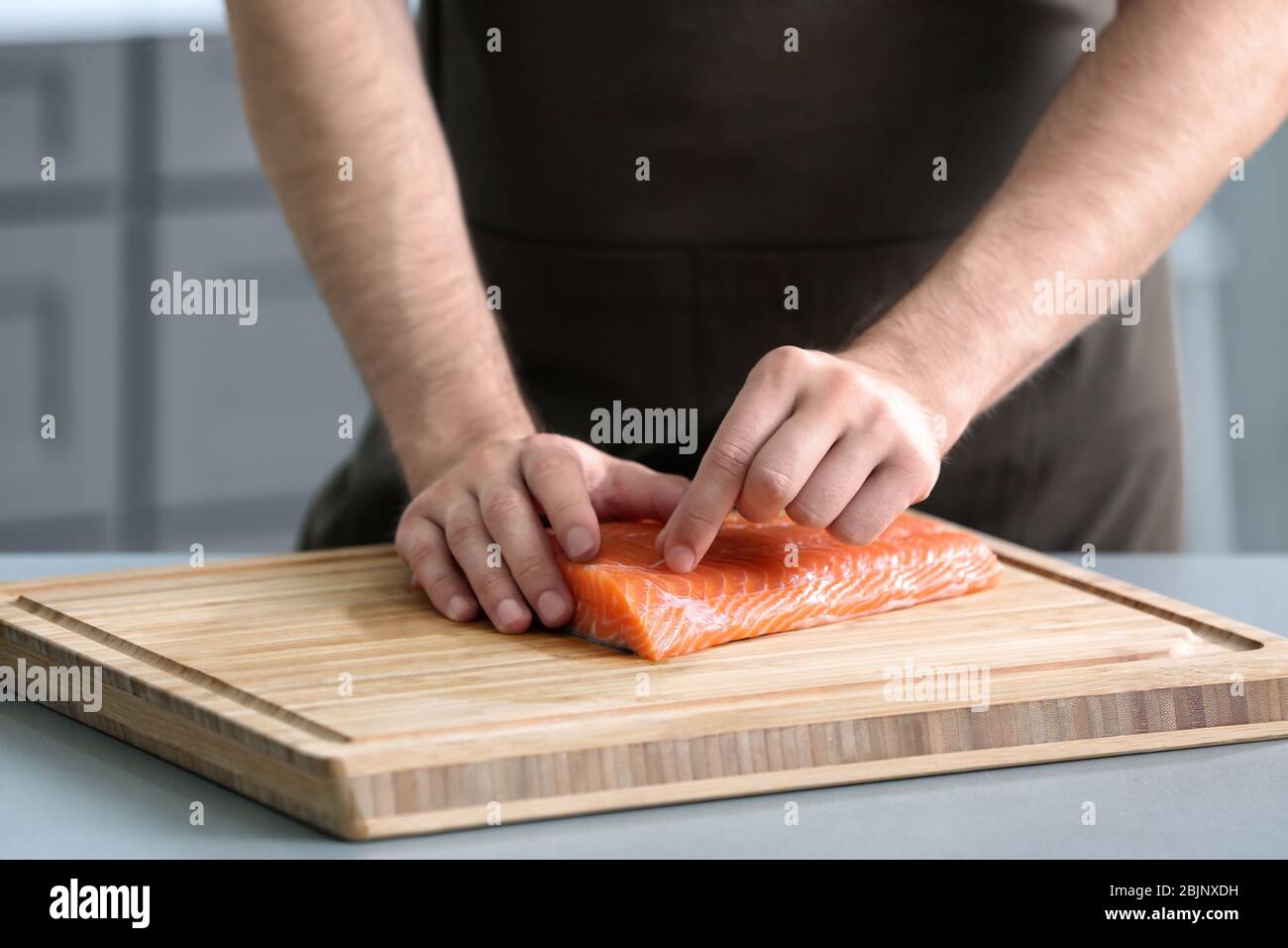 Man cooking salmon fillet in kitchen Stock Photo - Alamy