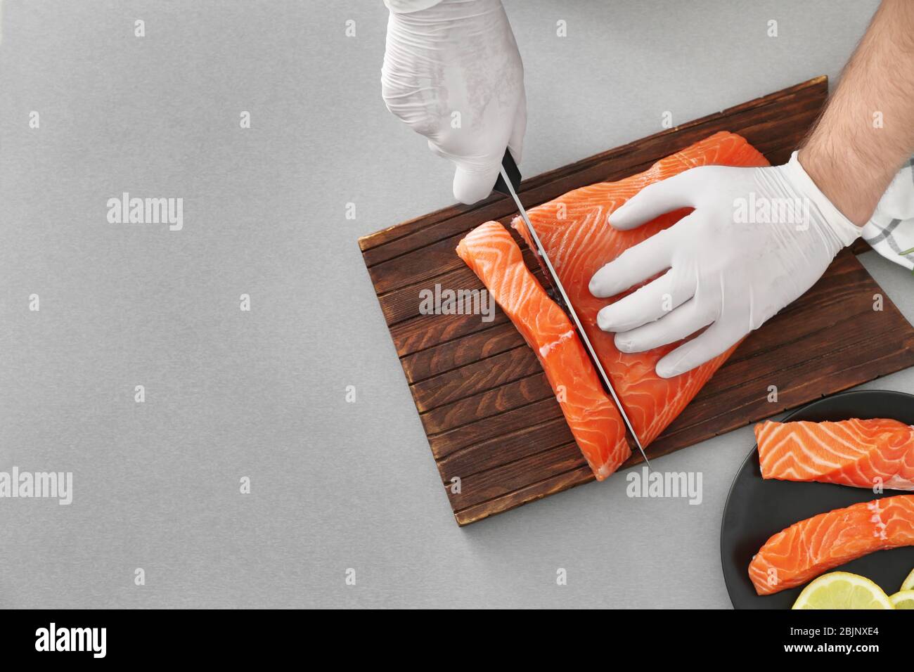 Man cutting fresh salmon fillet in kitchen Stock Photo - Alamy
