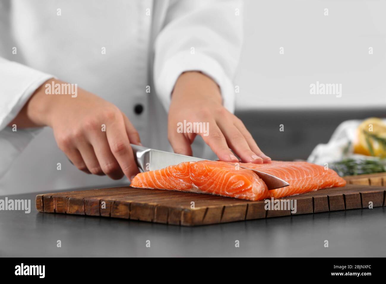 Female chef cutting fish knife hi-res stock photography and images - Alamy