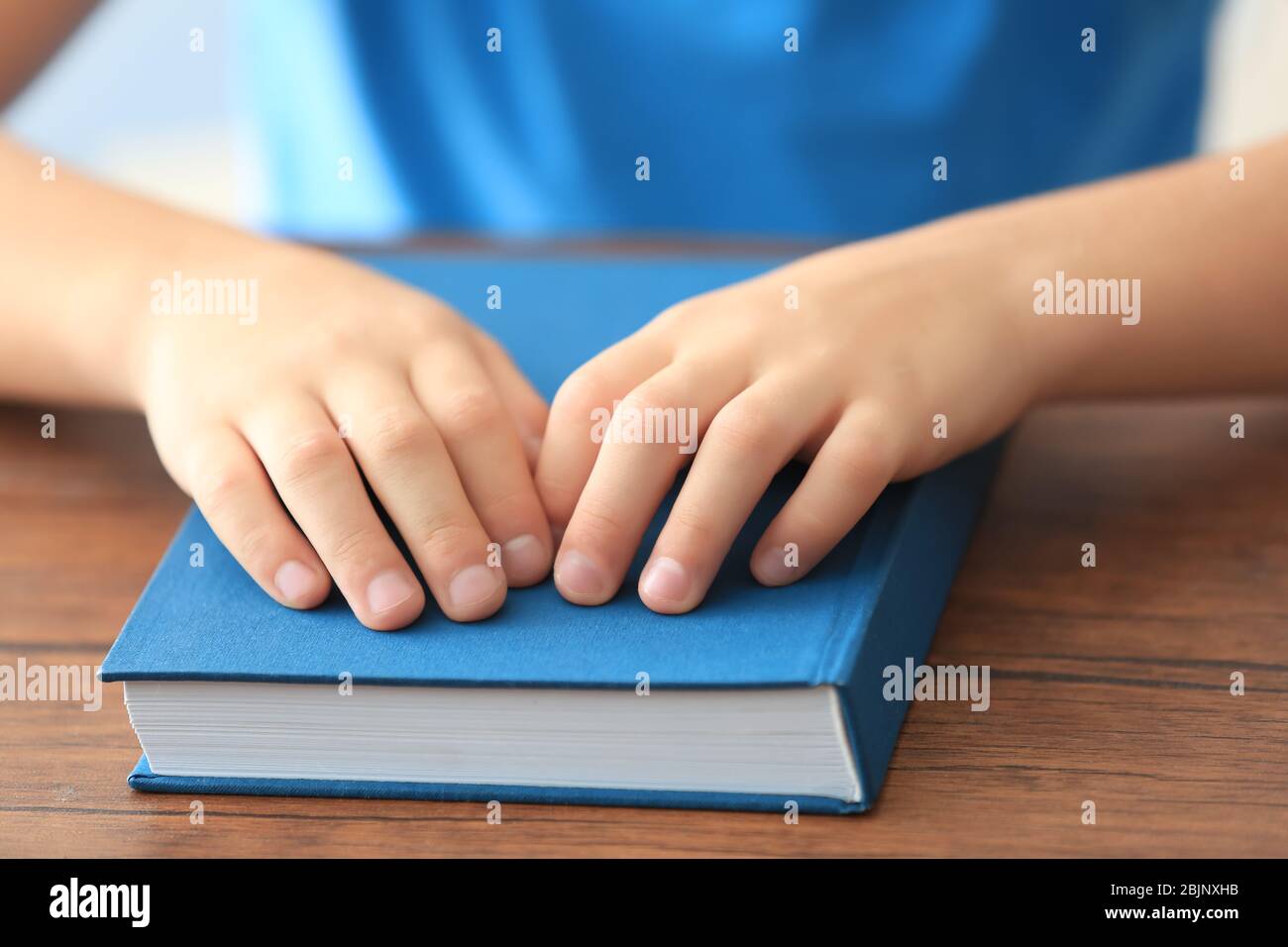 Cute little child with book at home, closeup Stock Photo - Alamy