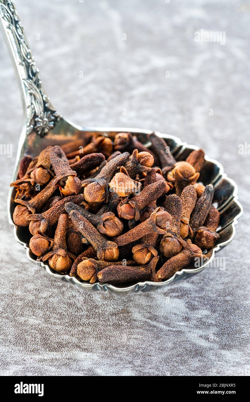 Whole cloves in a spoon - closeup with selective focus Stock Photo - Alamy