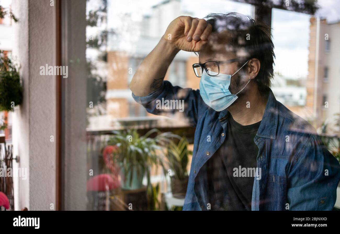 Man looking through window house sad hi-res stock photography and ...