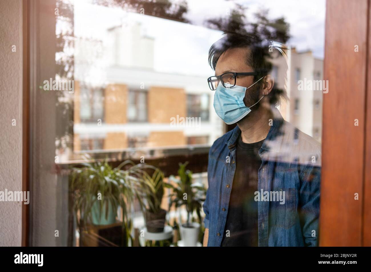 Man looking through window house sad hi-res stock photography and ...