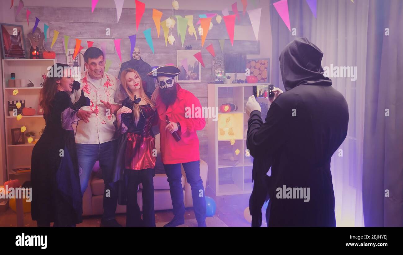 Spooky characters taking a group photo at halloween party in decorated ...