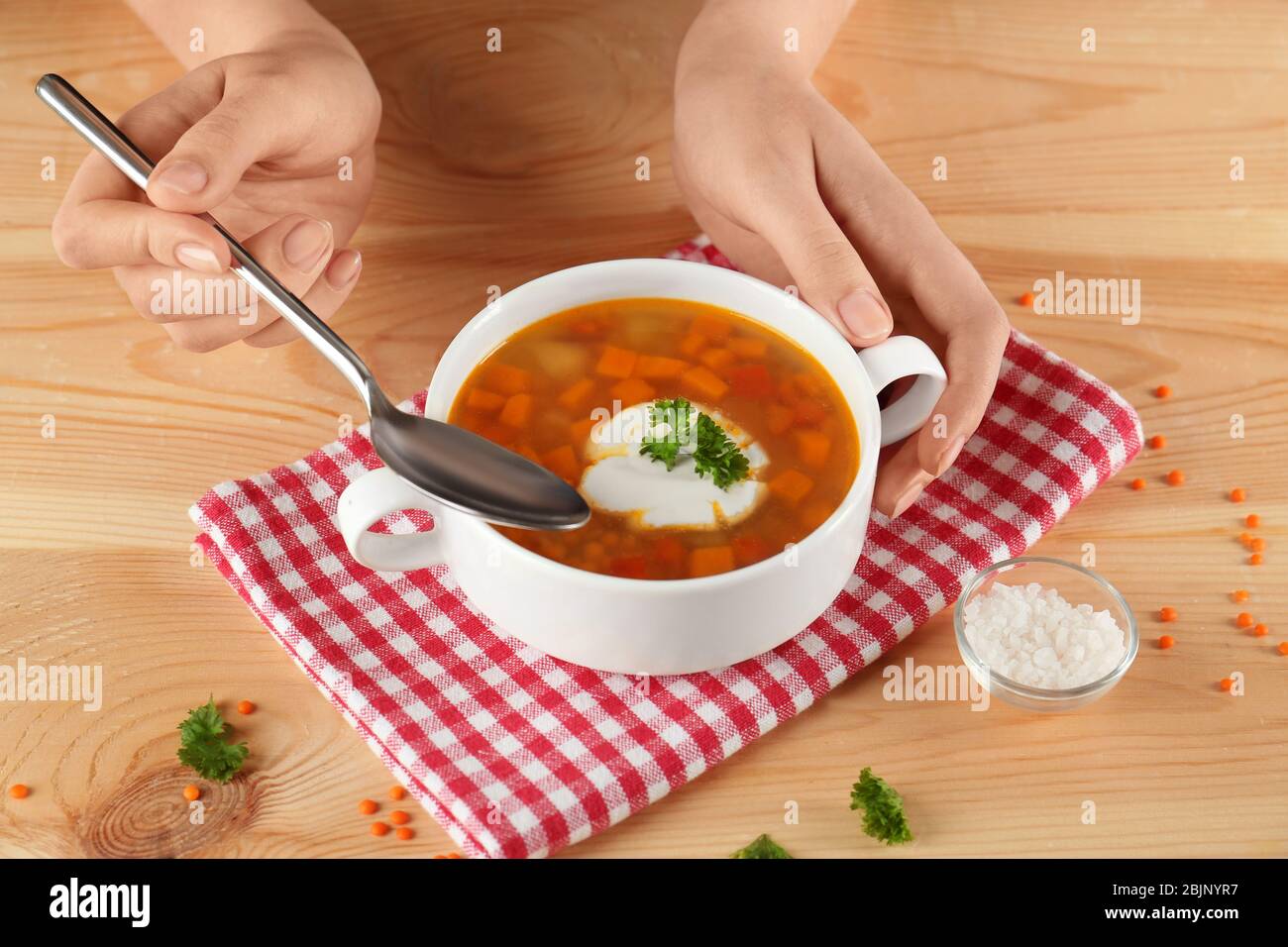 Woman eating tasty lentil soup at table Stock Photo - Alamy