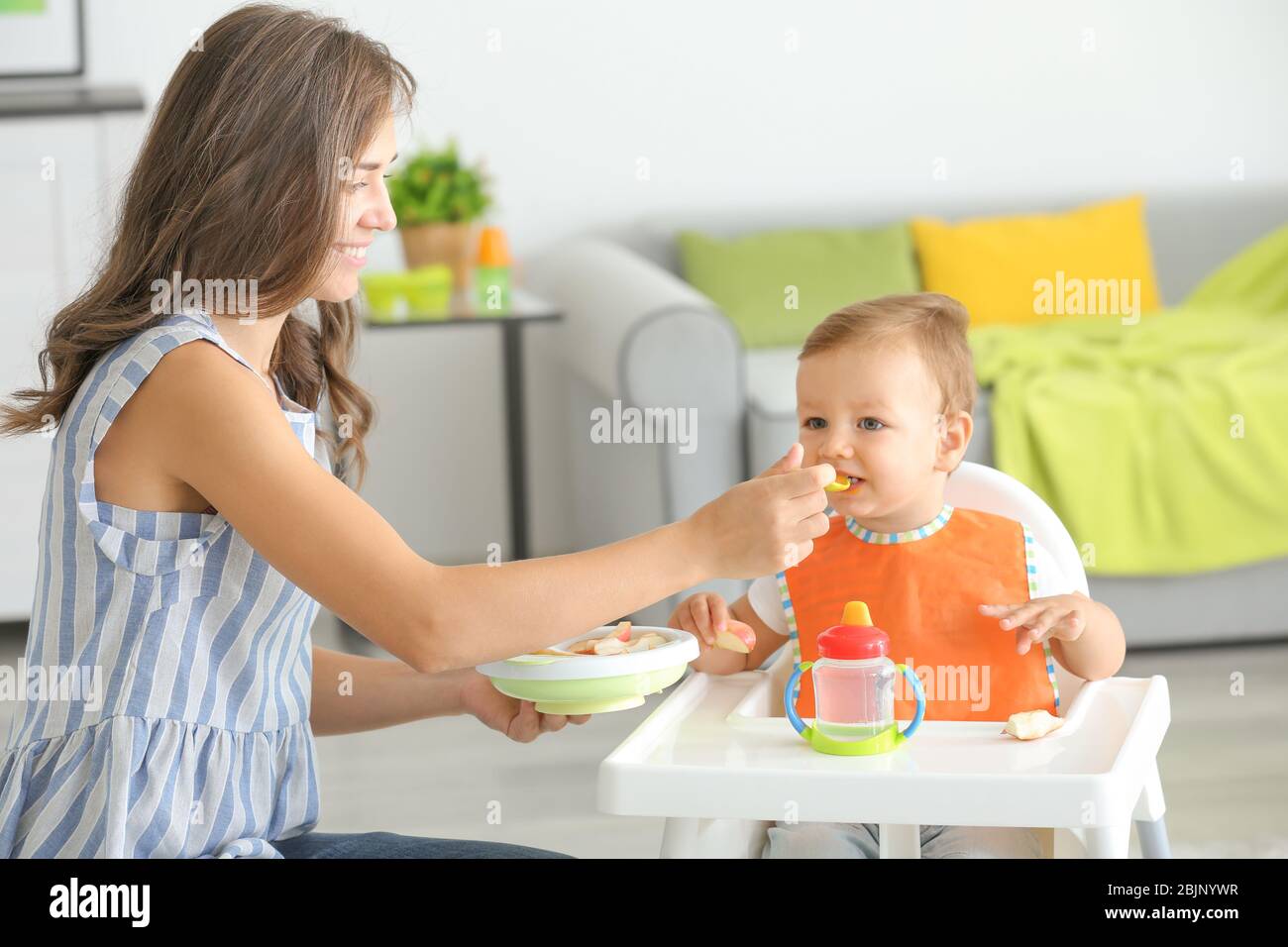 Woman feeding her baby at home Stock Photo - Alamy