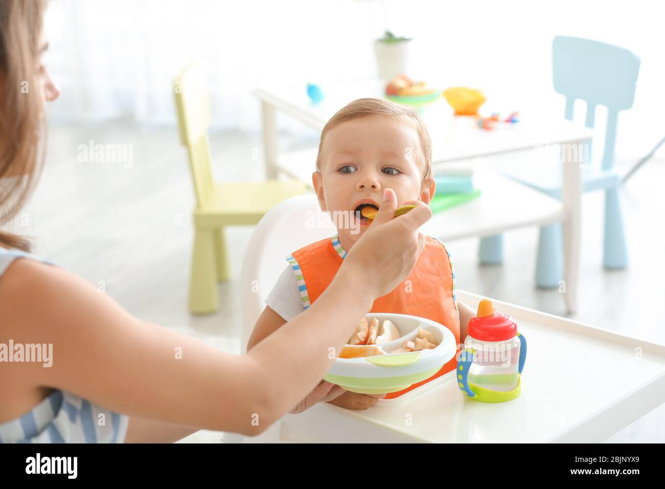 Woman feeding her baby at home Stock Photo - Alamy
