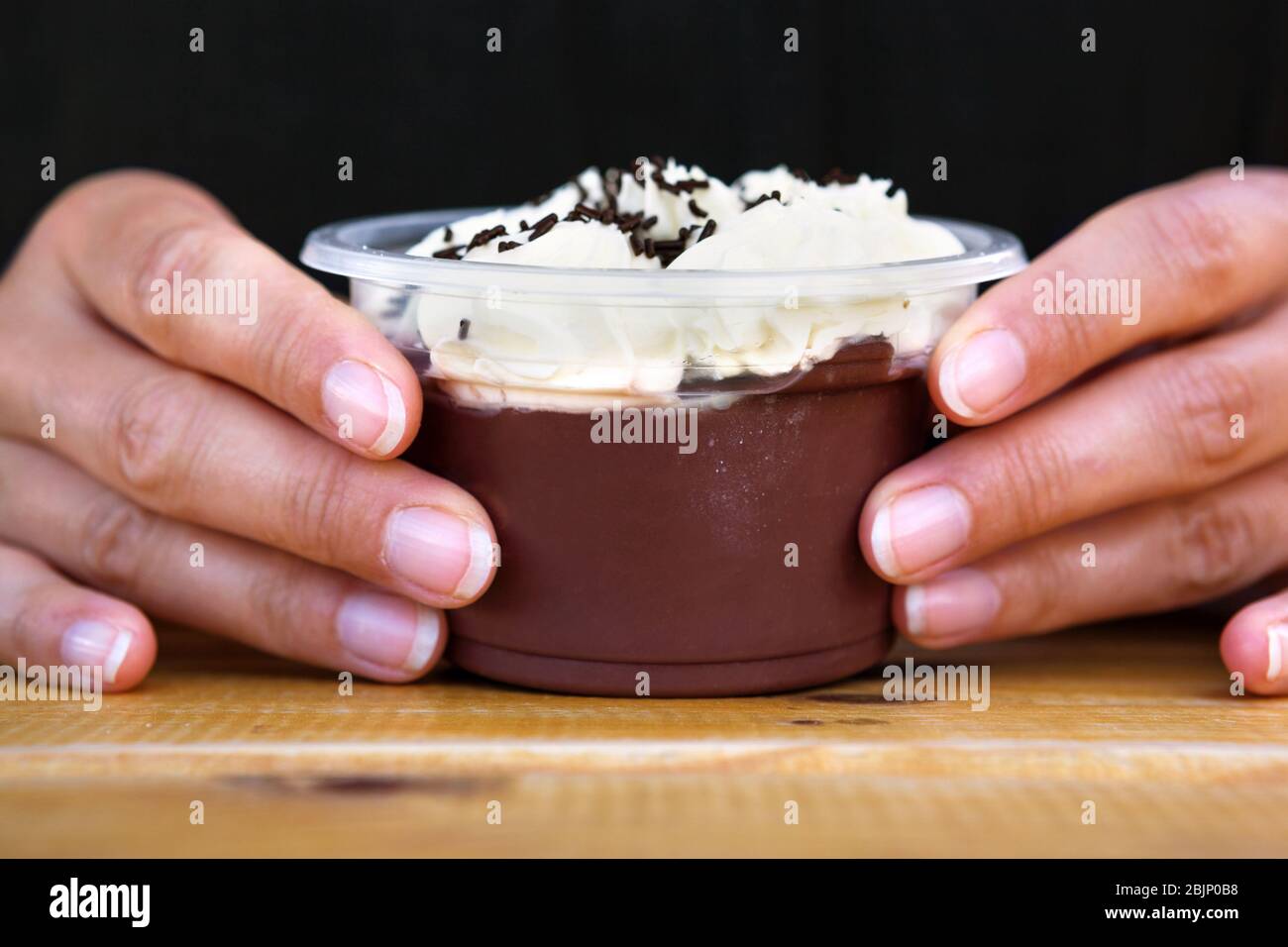Profiterole in takeaway box in woman hands ready to eat. Sweet dessert ...