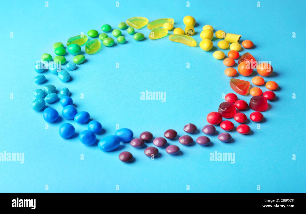 Colorful candies arranged as circle on blue background Stock Photo - Alamy