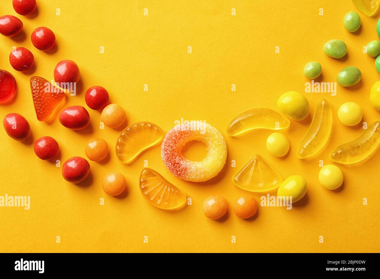 Colorful candies arranged as semi circle on yellow background Stock ...