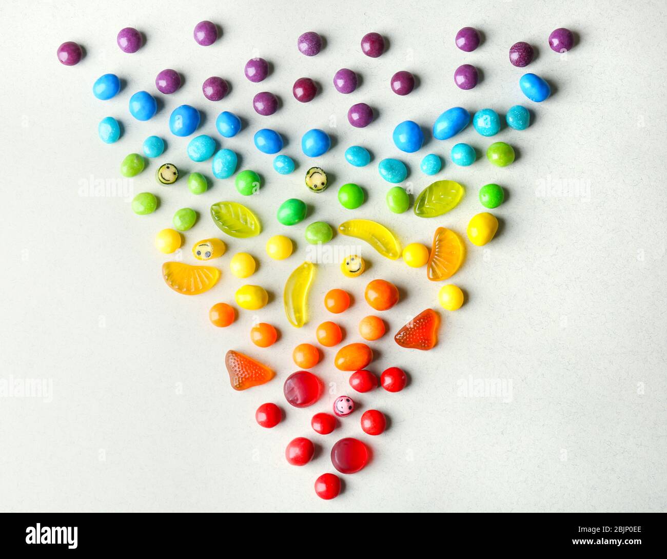 Colorful candies arranged as triangle on light background Stock Photo ...