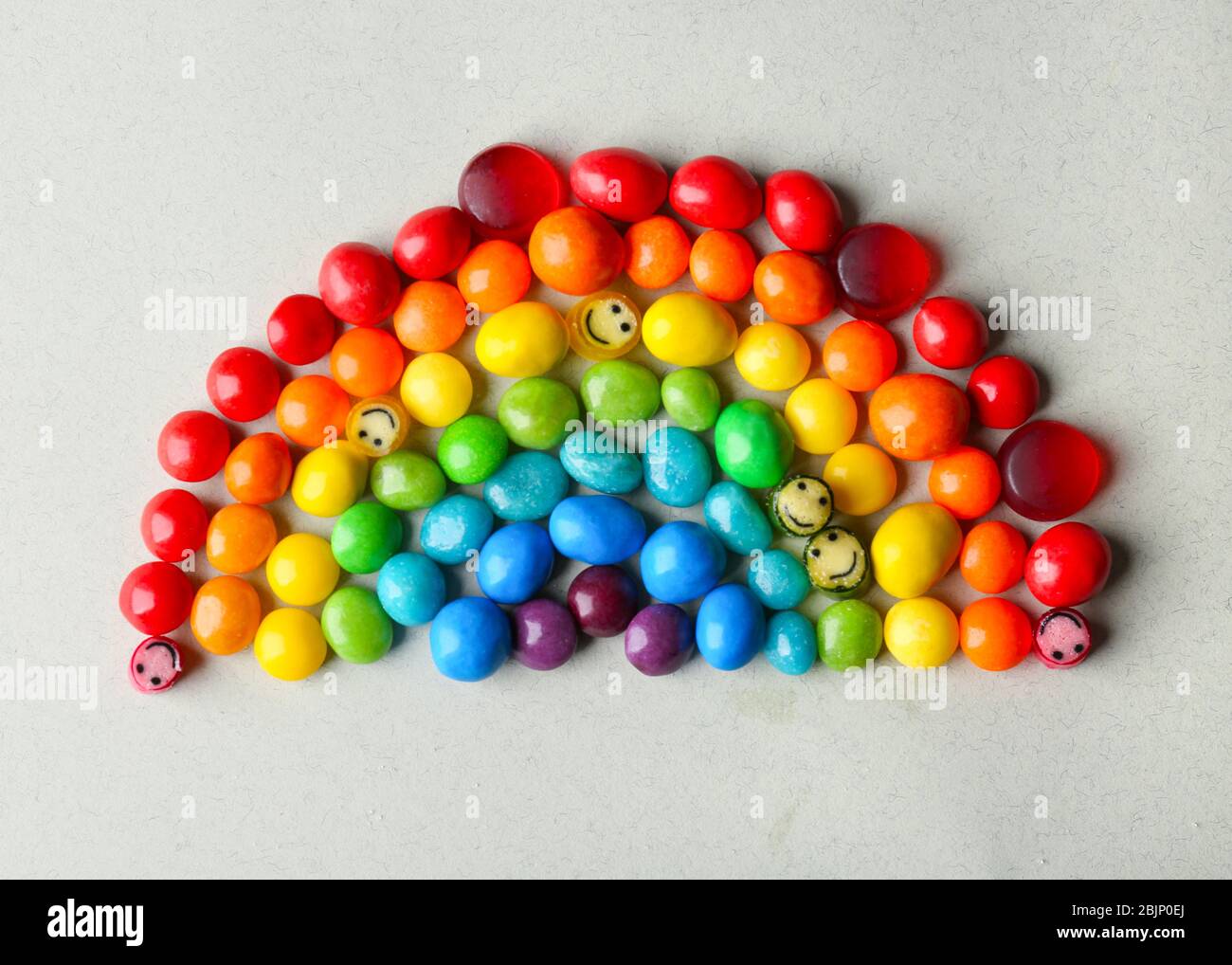 Colorful candies arranged as rainbow on light background Stock Photo ...