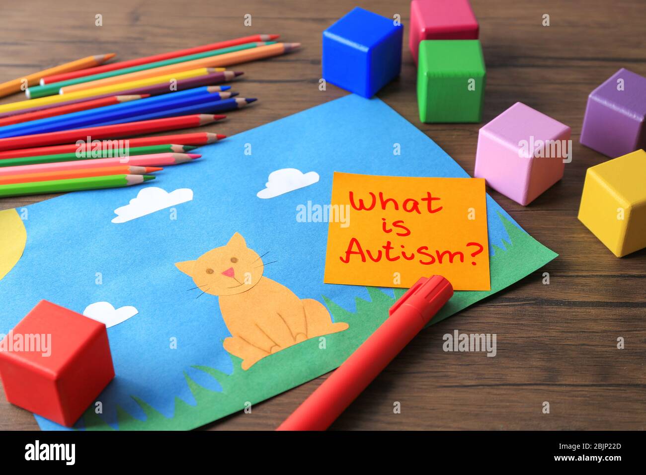 Childish applique and sticky note with words What is autism on wooden ...