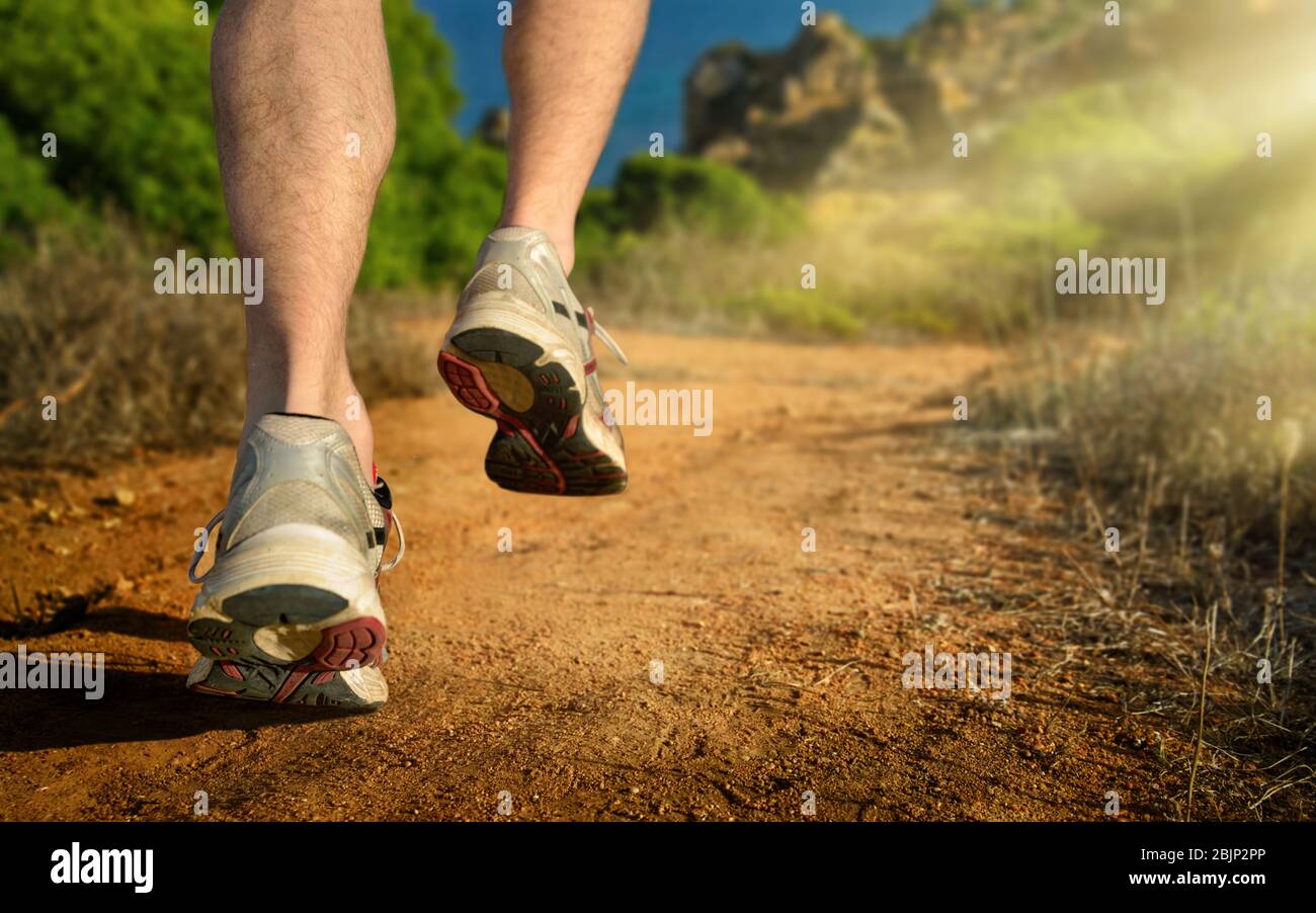 Running outdoors in the mountains by the sea, a dynamic closeup of the ...