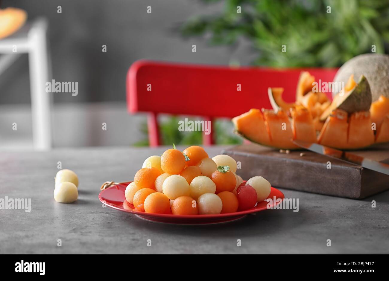 Plate with fresh fruit balls on table Stock Photo - Alamy