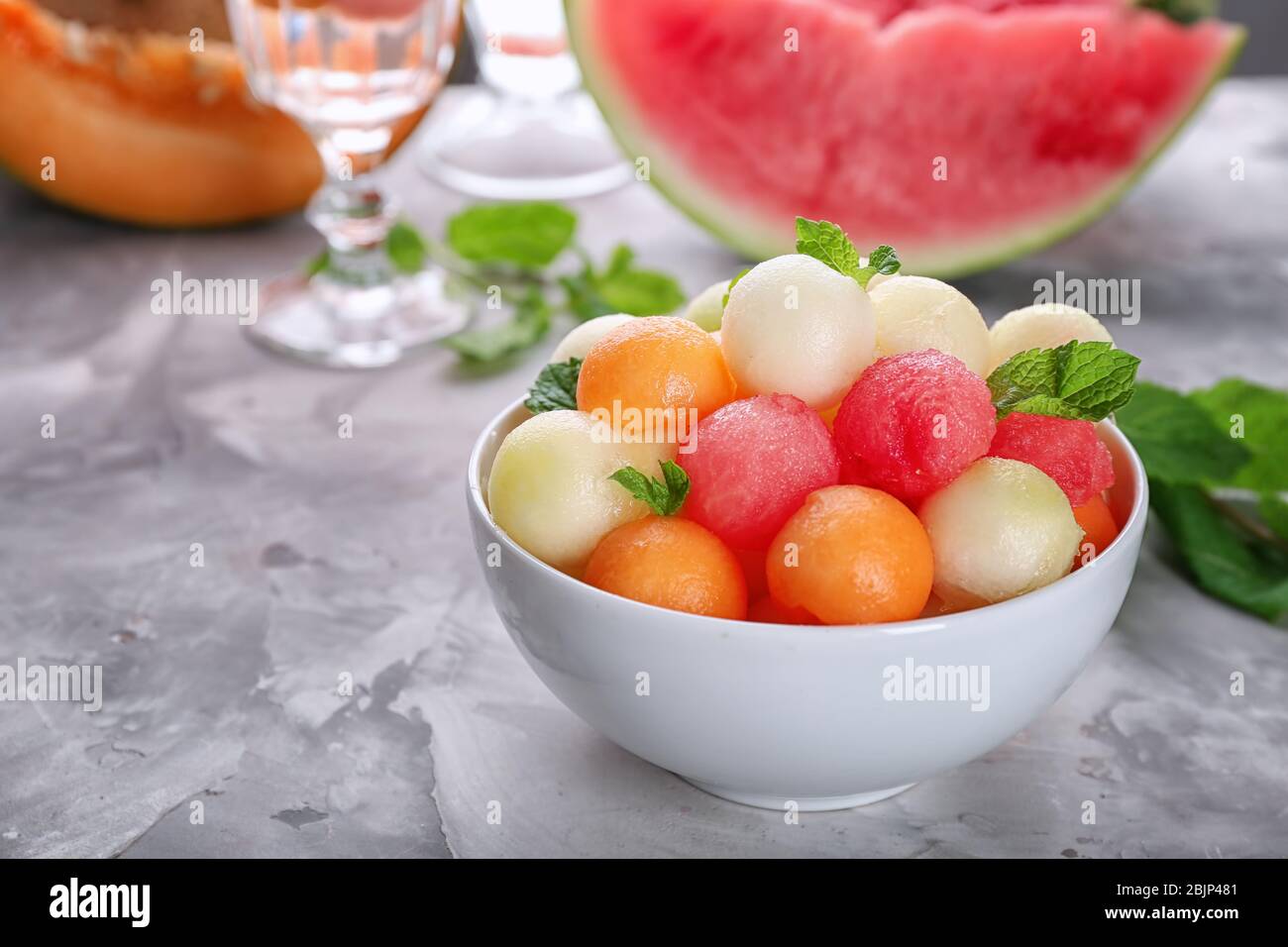 Bowl with fresh fruit balls on table Stock Photo - Alamy