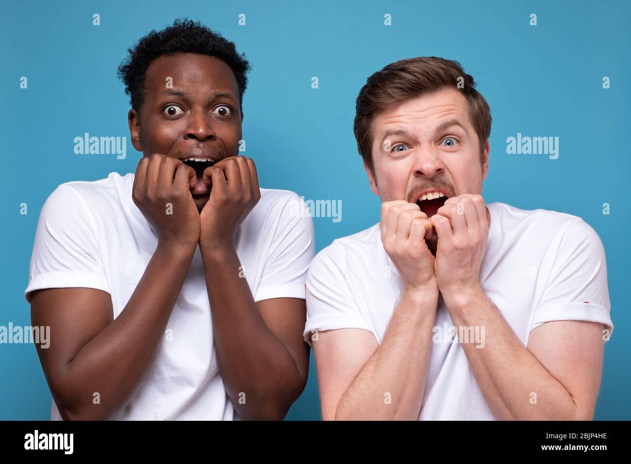 Frightened two men have scared expressions, look nervously, isolated ...