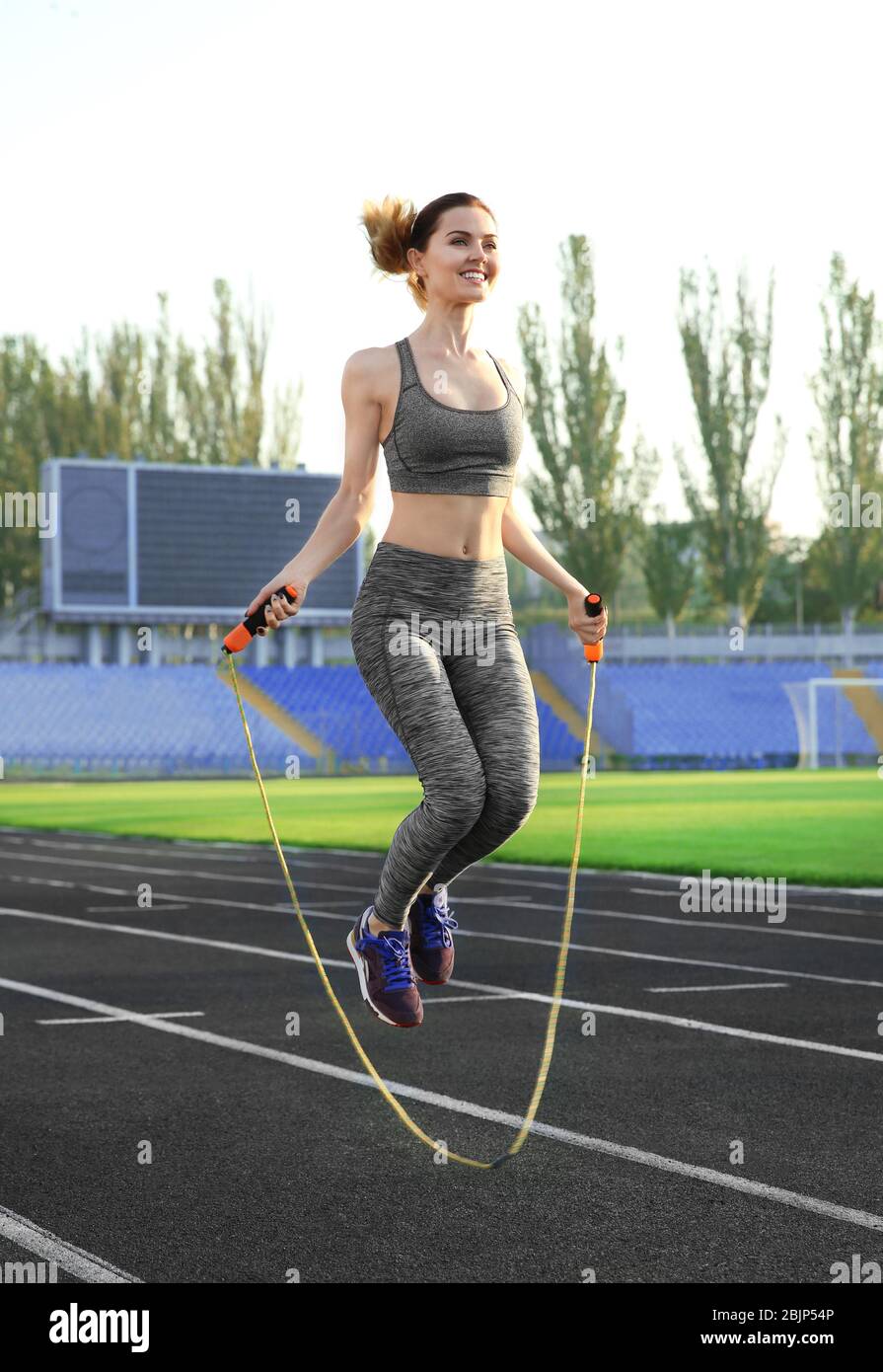 Young sporty woman jumping rope in stadium Stock Photo - Alamy