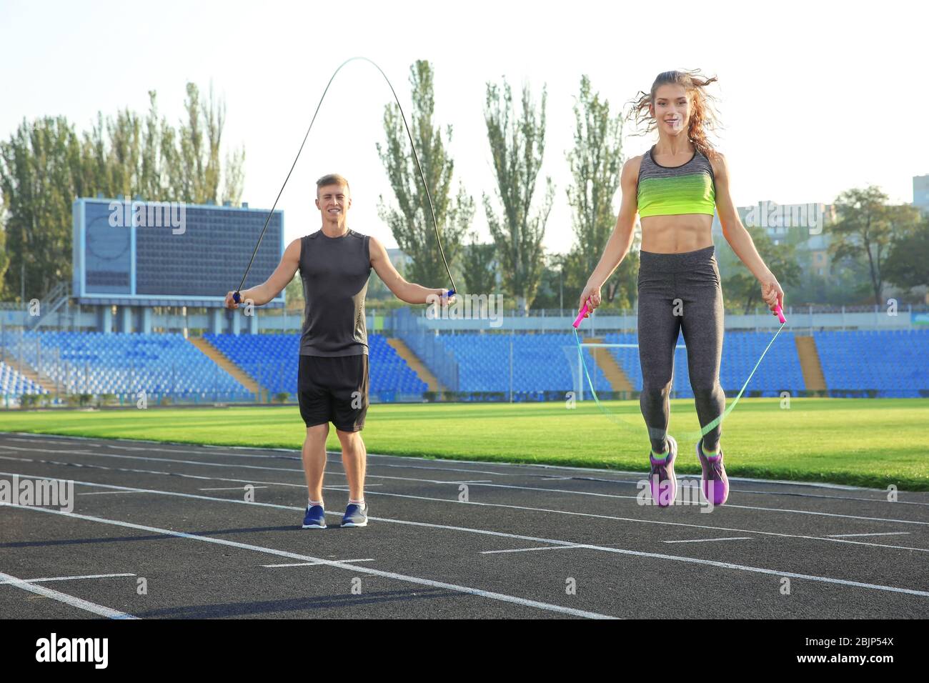 Young sporty people jumping rope in stadium Stock Photo - Alamy