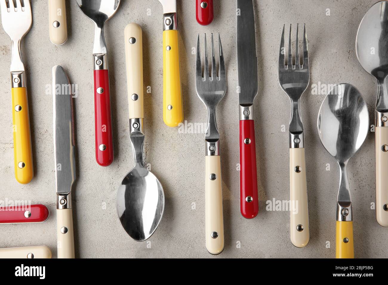 Set of cutlery on light textured background Stock Photo - Alamy