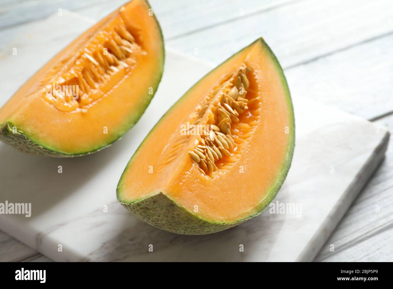 Marble board with slices of fresh ripe melon on table, closeup Stock ...