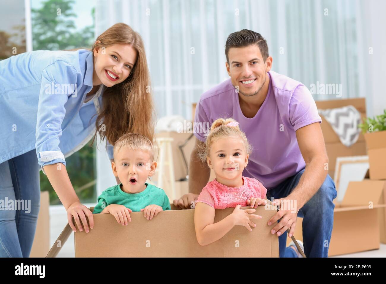 Happy family with moving box in their new house Stock Photo - Alamy