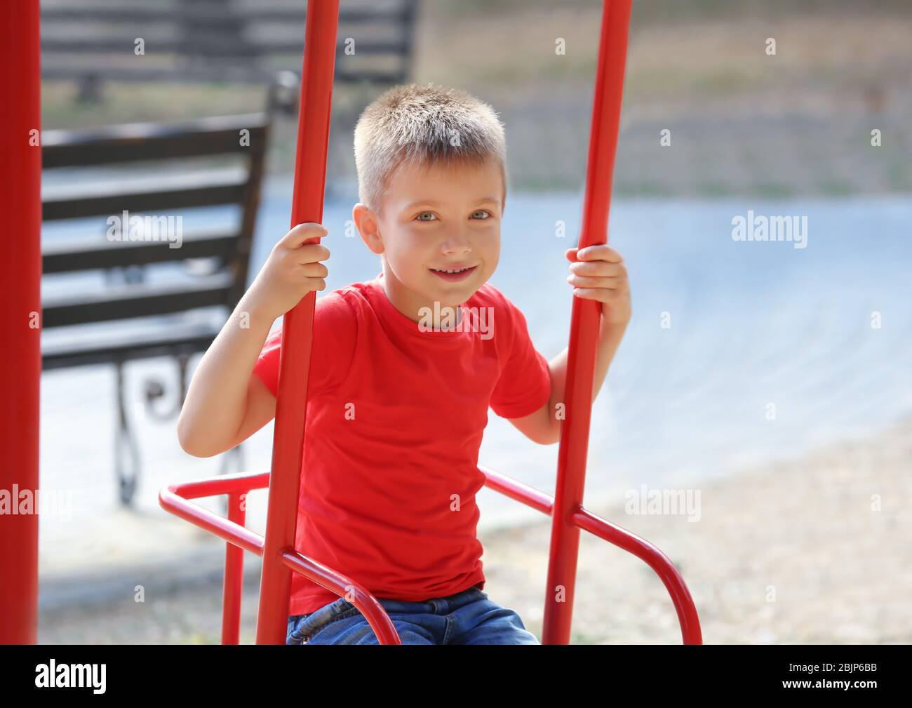 Adorable little boy on swing at playground Stock Photo - Alamy