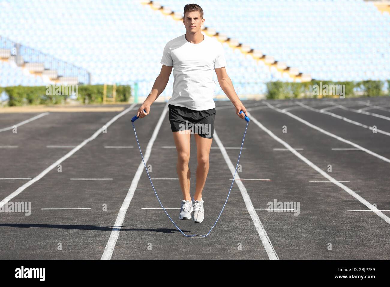 Young man skipping rope at stadium Stock Photo - Alamy