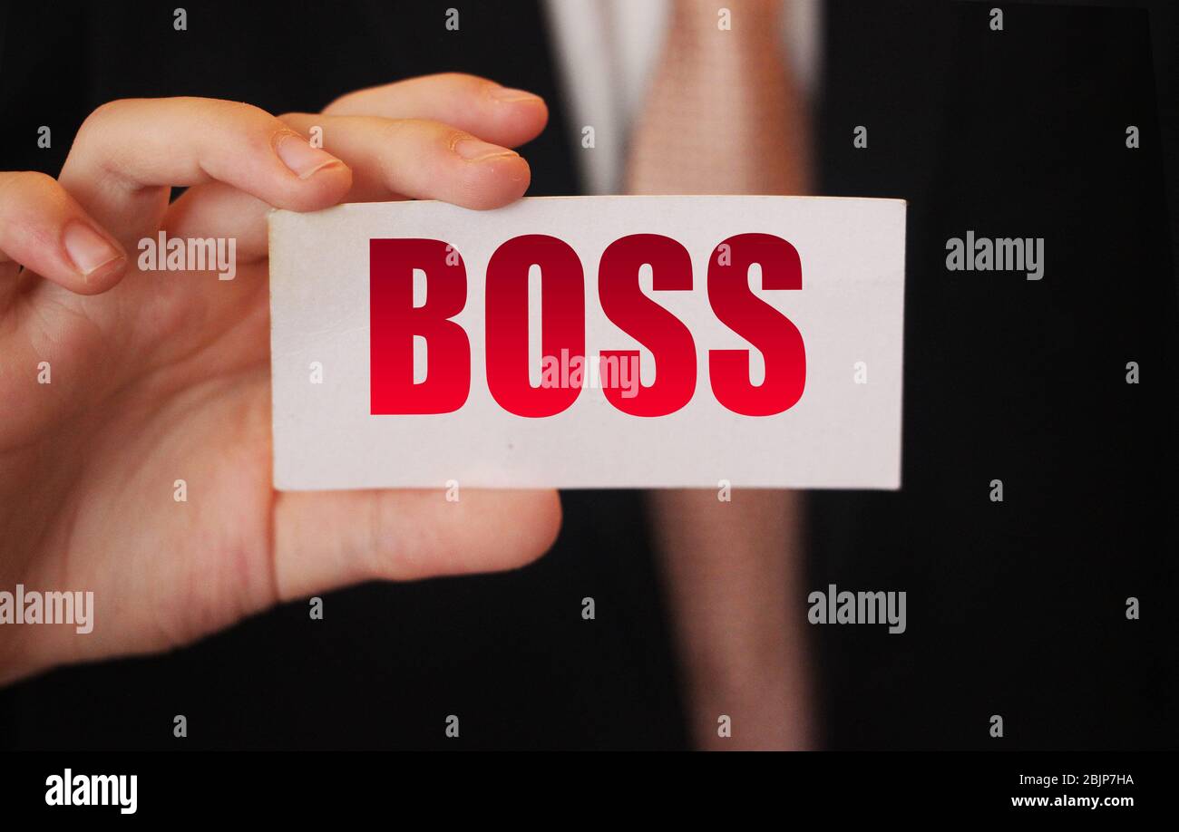 Businessman shows a card with word BOSS. CEO or general manager ...