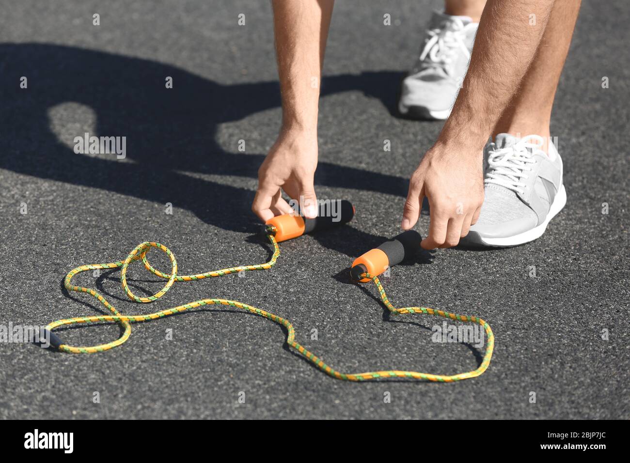 Young man with jumping rope at stadium Stock Photo - Alamy