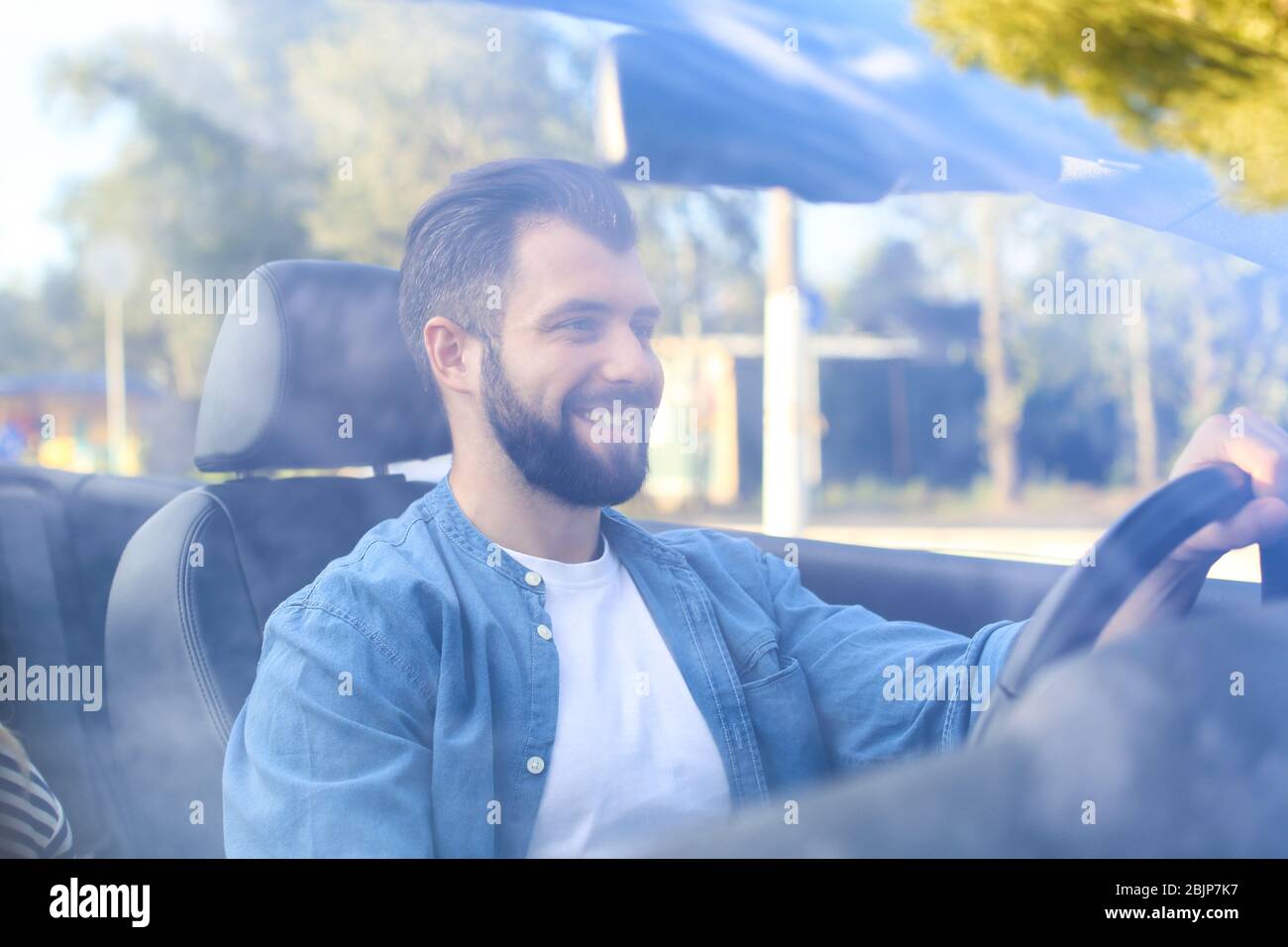 Happy young man driving a car, view through windshield Stock Photo - Alamy