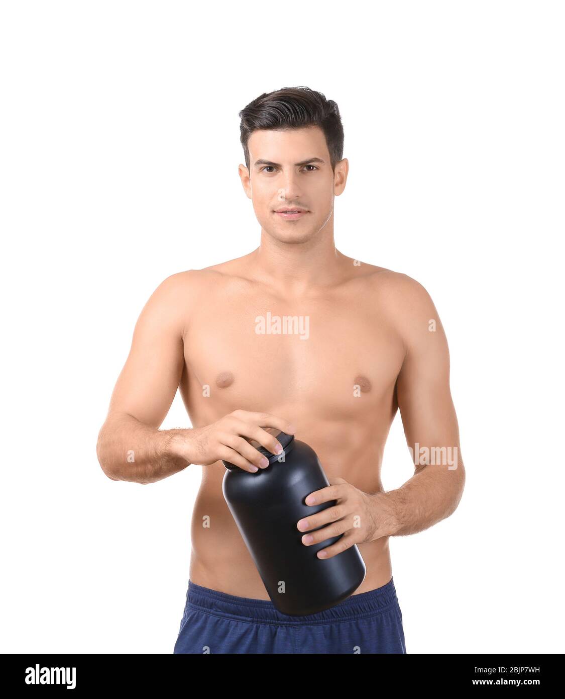 Shirtless young man holding black jar with protein powder on white ...