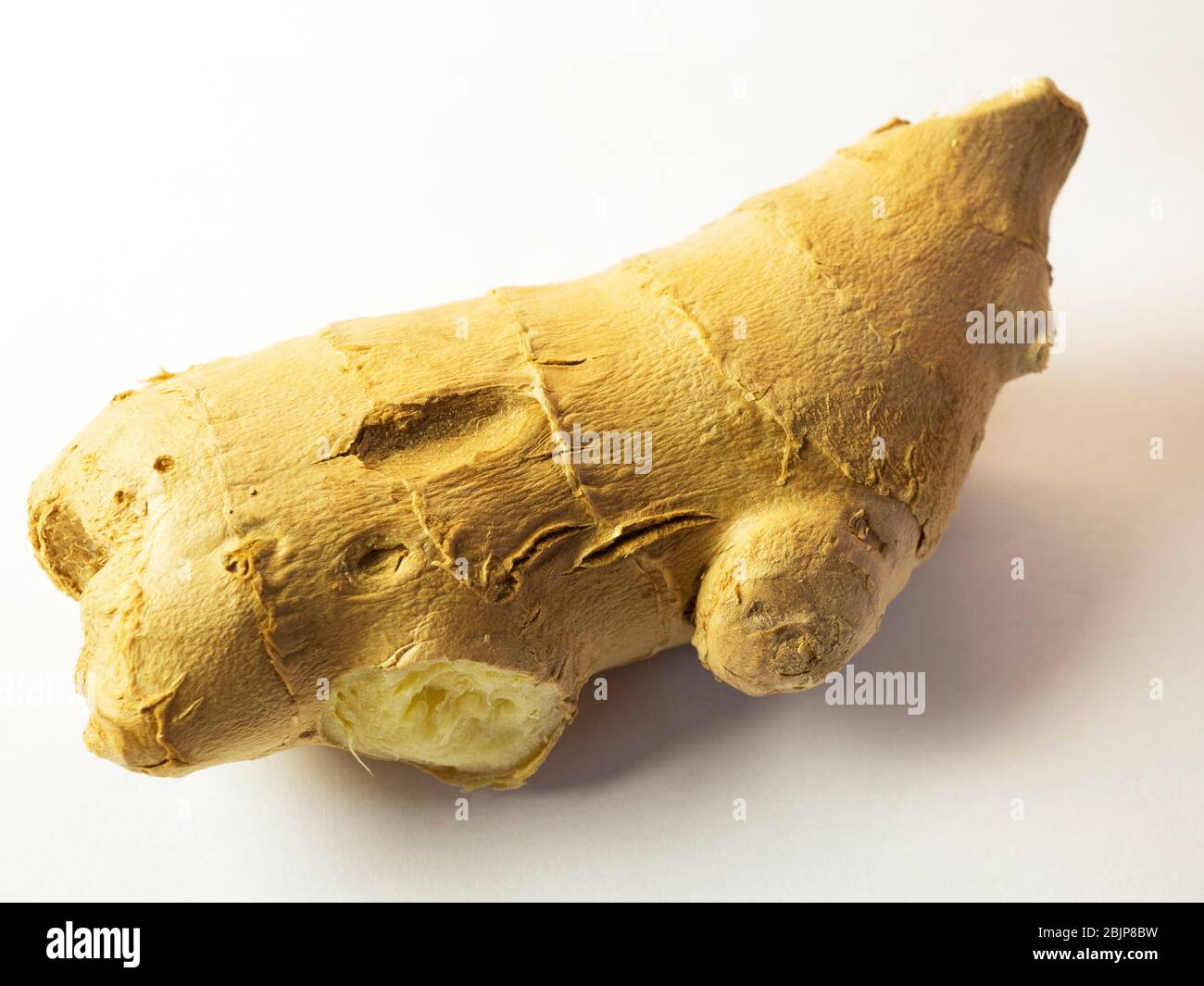 A single thumb of ginger on a white background Stock Photo - Alamy