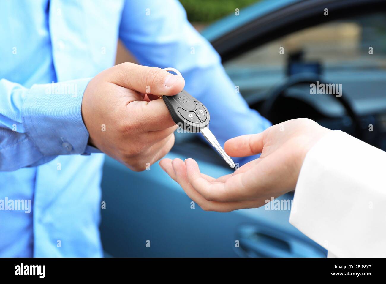 Salesman giving car key to customer outdoors Stock Photo - Alamy