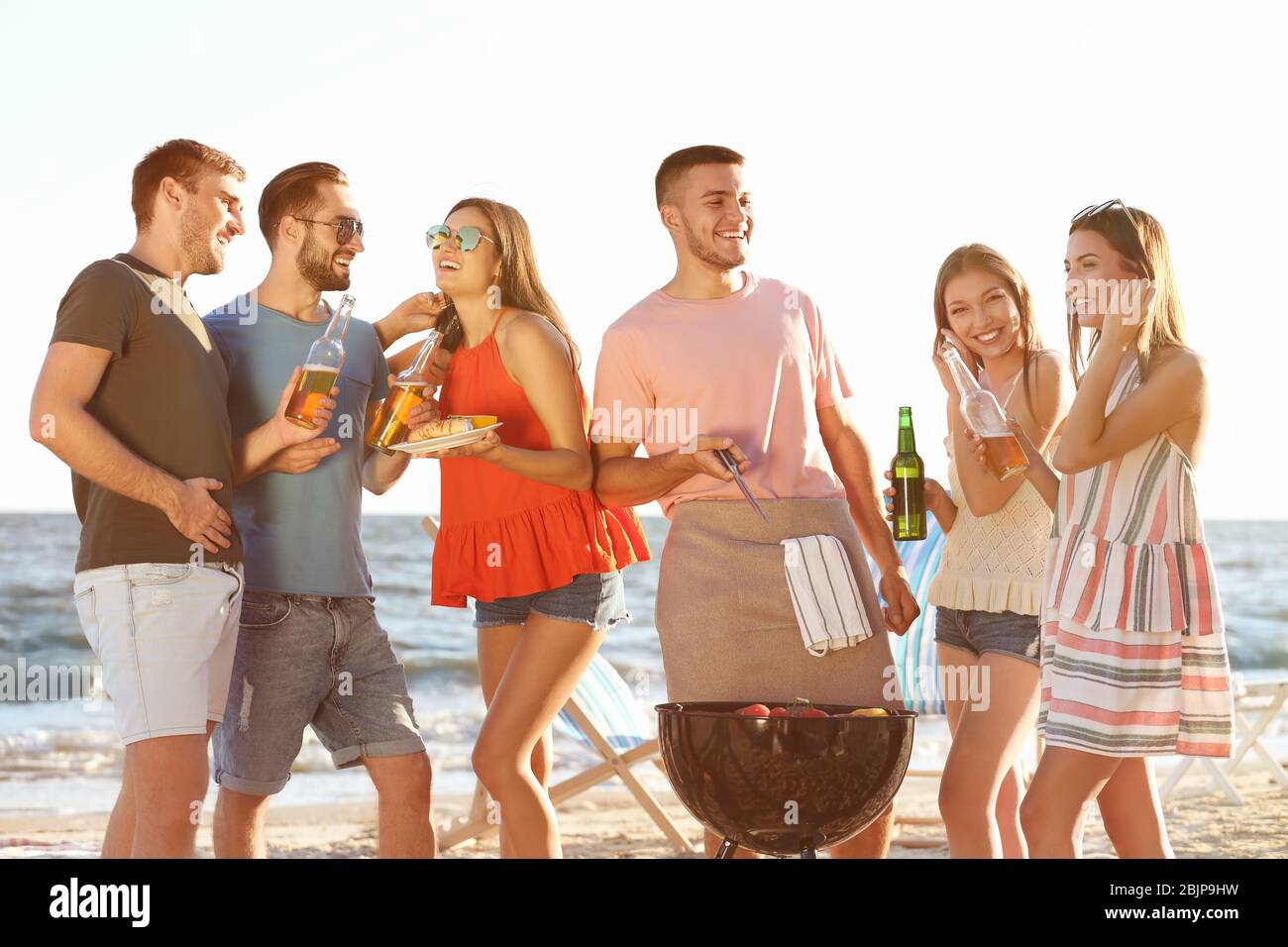Young people having barbecue party on beach Stock Photo - Alamy